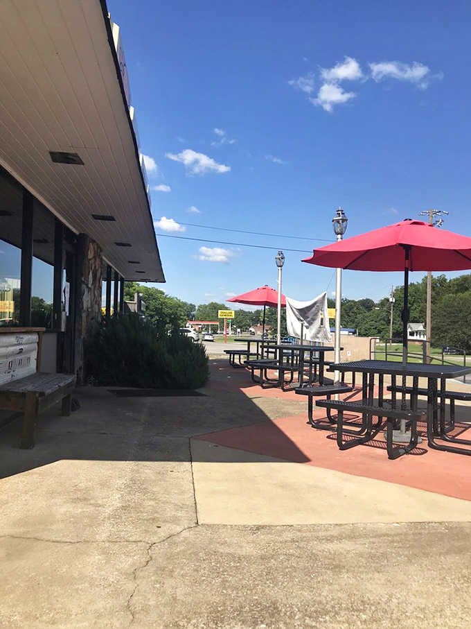 Those red umbrellas provide shade for outdoor dining under blue skies, where barbecue tastes even better in fresh air.