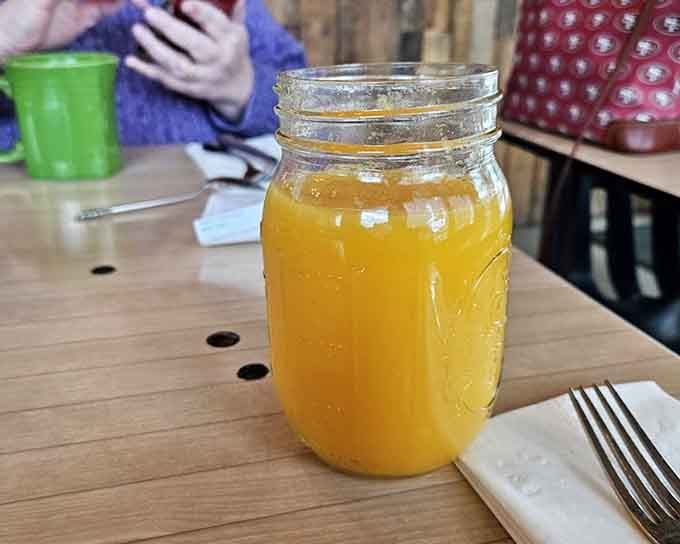 Fresh orange juice in a mason jar, because even your beverage knows this isn't your average corporate breakfast joint.