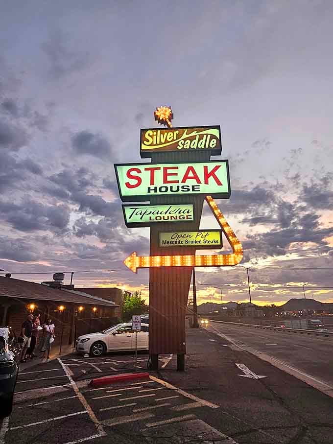That illuminated vintage sign at sunset looks like something from a classic road trip movie, absolutely magnificent.