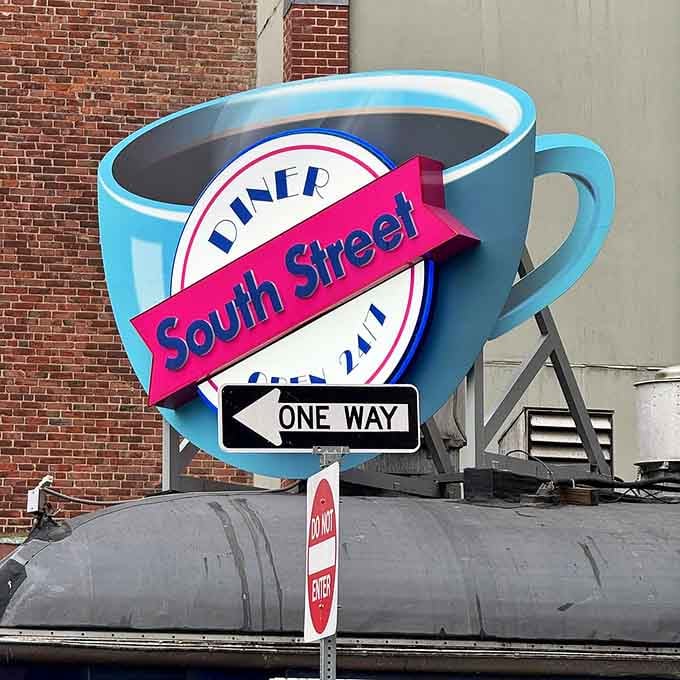 The iconic coffee cup sign towers above like a caffeinated superhero, watching over Boston's hungry masses with benevolent vigilance.