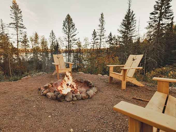 Adirondack chairs circle a stone fire pit where marshmallows meet their delicious destiny under a canopy of stars.