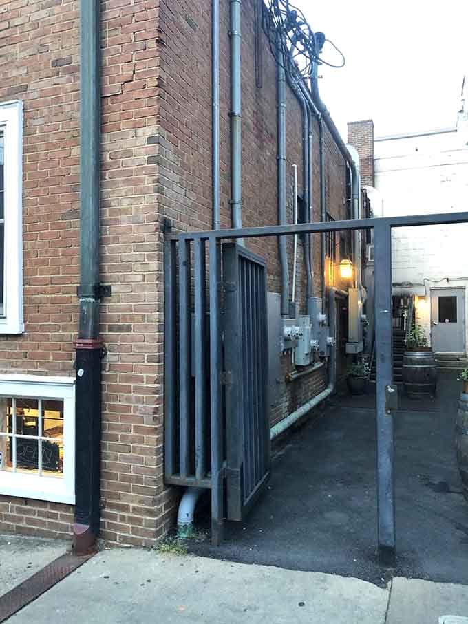 The alley entrance, lit by a single lantern, beckoning you toward one of Charlottesville's best-kept secrets.