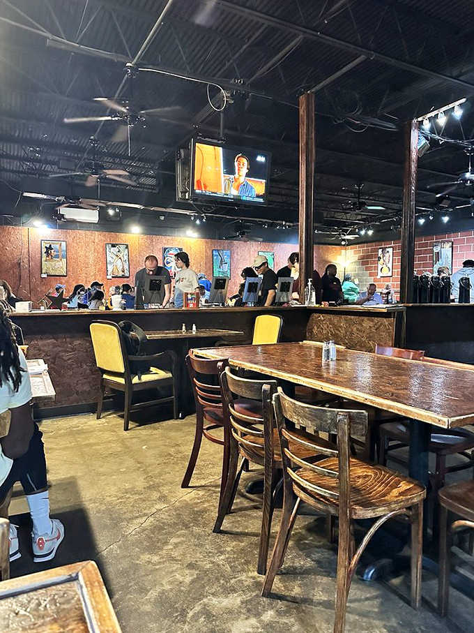 Another angle of the bustling interior where TVs, artwork, and happy diners create the perfect breakfast atmosphere together.
