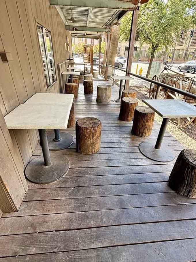 Outdoor seating with tree stump stools and wooden tables where you can enjoy Arizona weather with your charcoal-grilled masterpiece.