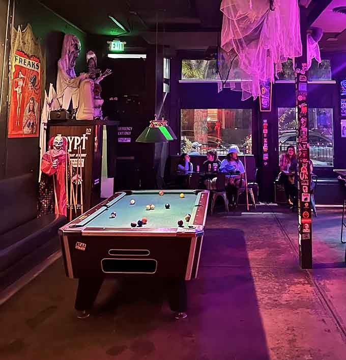 The pool table sits ready for action beneath purple haze, where you can sink balls while surrounded by cinematic nightmares.