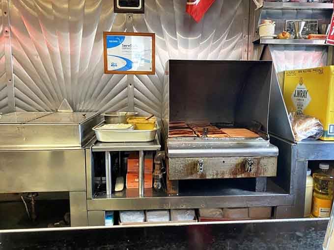 The cooking station where magic happens, hot dogs meeting flames in a dance perfected over eight decades of practice.
