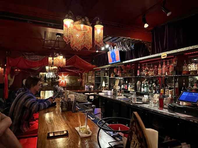 The bar area glows with warmth and character, chandeliers adding unexpected elegance to the comic book vibe.
