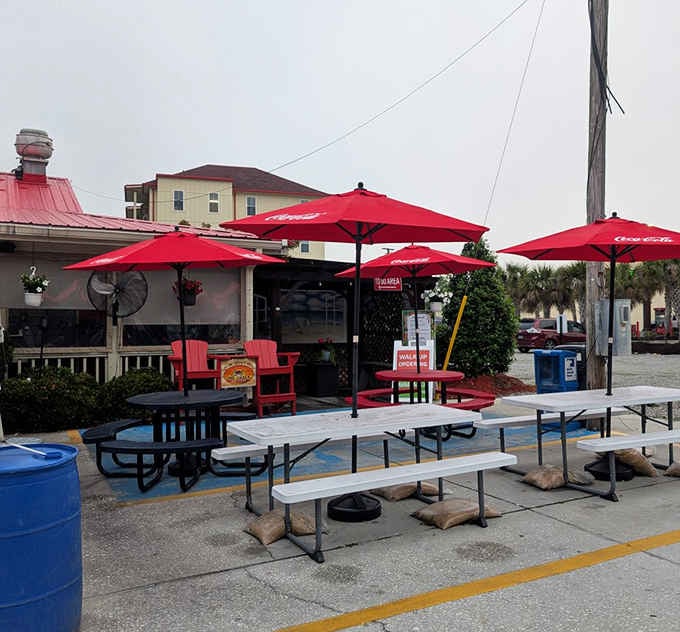 Outdoor seating with red umbrellas lets you enjoy your seafood feast while soaking up that coastal sunshine.