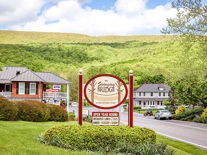 That welcoming sign against green mountains basically says "you've arrived somewhere special, friend."