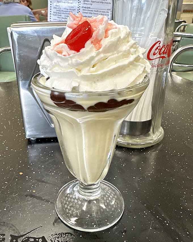 Whipped cream piled high like a delicious cloud, crowned with a cherry because some rules are worth following.