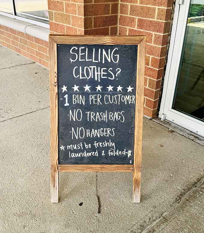 Sidewalk sign laying down the selling rules: freshly laundered, folded, no trash bags, because standards matter here.