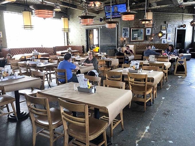 Diners enjoying their meals in this spacious, industrial-chic setting that honors Michigan's rich automotive heritage perfectly.