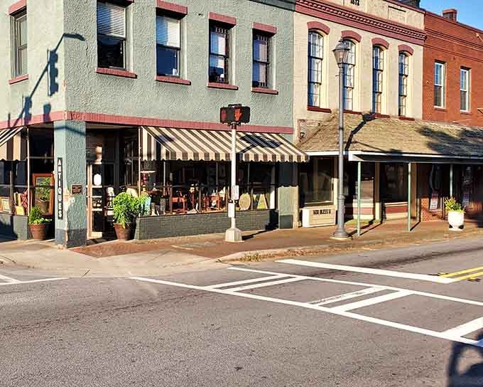 Striped awnings and potted plants soften the streetscape, creating an inviting atmosphere that beckons you to slow down and browse.