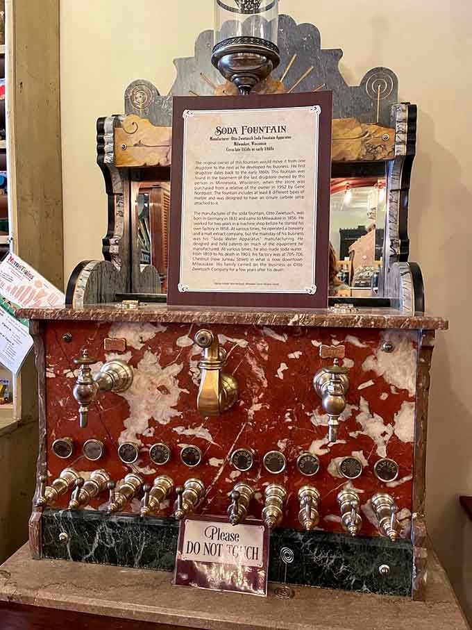 The old soda fountain machinery sits preserved behind a "do not touch" sign, a testament to craftsmanship from another century.