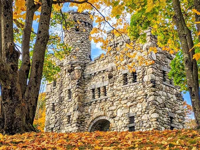 Fall foliage frames this stone tower like nature's own picture frame, creating a scene straight from Camelot.