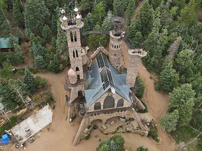 Stone towers rise from the pines like a medieval dream built by hand over decades of dedication.