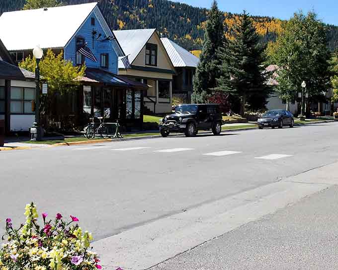 Victorian charm meets mountain majesty where colorful storefronts line peaceful streets beneath golden aspens.