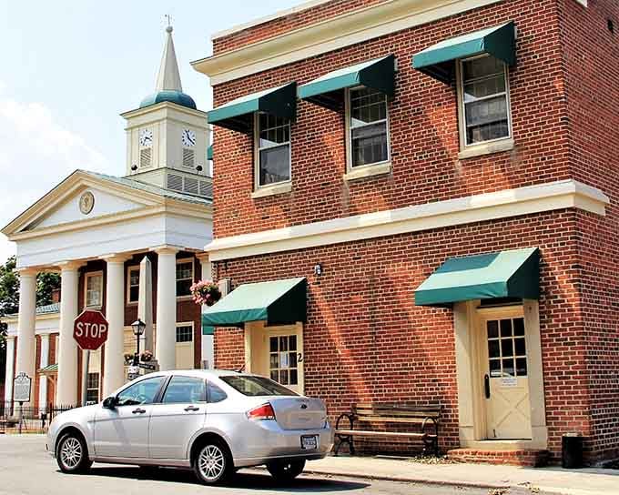 Those green awnings against red brick create a harmony that would make any architect weep with joy.