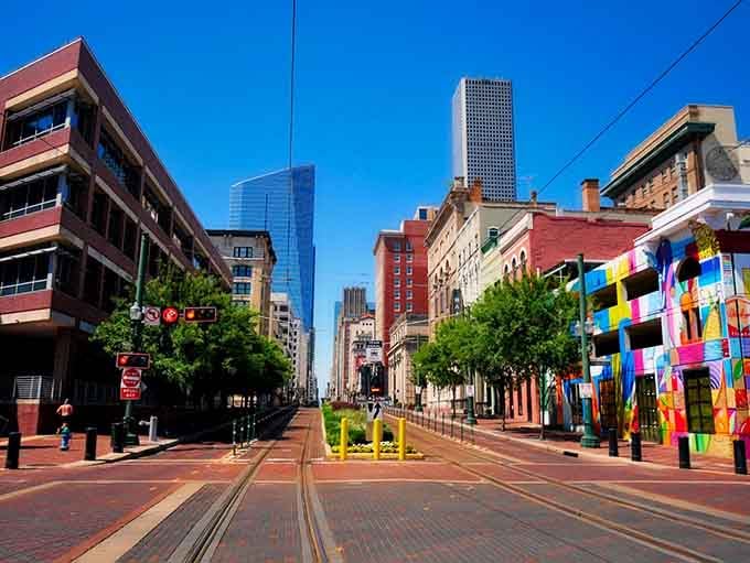 Downtown Houston blends old brick charm with gleaming towers, where colorful street art meets serious business under endless blue skies.