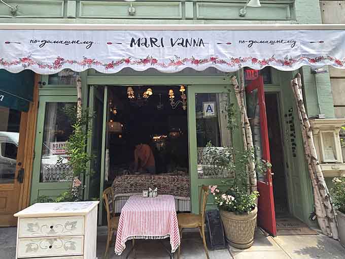 That floral awning and birch branches framing the entrance whisper "come inside" like a Russian grandmother's warm invitation.