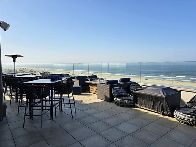 Glass barriers frame endless ocean views where waves meet sky in perfect California harmony.