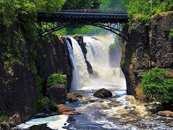 That historic bridge frames nature's power show perfectly—77 feet of thundering water that'll make your heart skip.