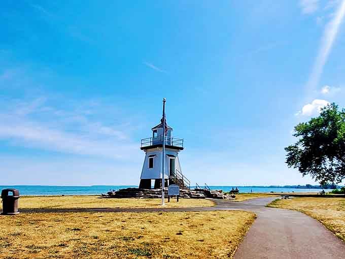 This charming blue and white beacon sits on golden sand like a miniature coastal dream come true.
