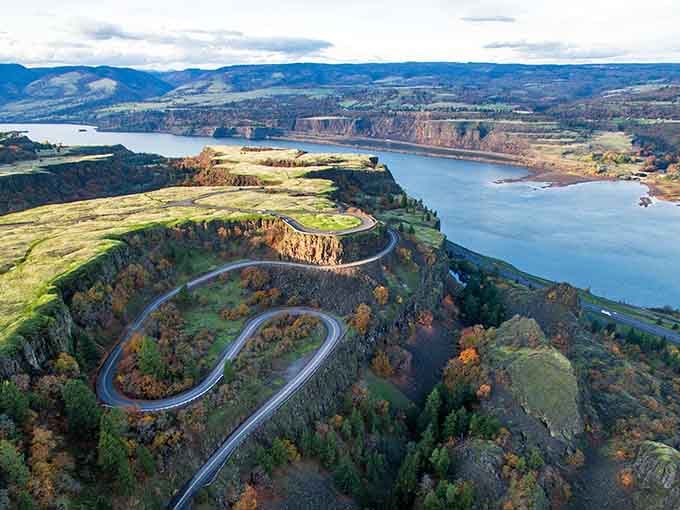 That winding road looks like nature drew it with a spirograph, hugging cliffs above the Columbia River's shimmering waters.