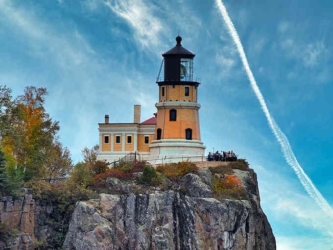 Perched on dramatic cliffs like a castle, this golden beacon commands Lake Superior with autumn colors blazing below.