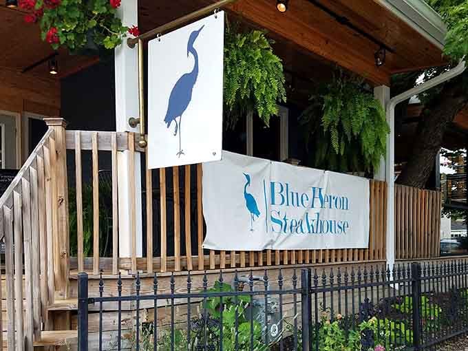 That elegant blue heron logo promises something special, and the lush greenery creates a welcoming oasis.