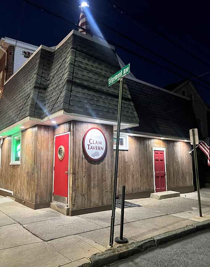 That weathered wood exterior and glowing red door at night promise fresh clams worth every single mile.
