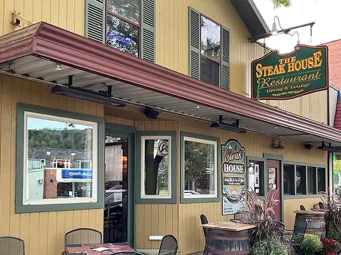 That cheerful yellow exterior with green trim practically shouts "come on in, friend" before you even smell the steaks.