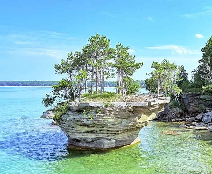 Nature's balancing act creates this impossible rock formation crowned with trees over crystal-clear turquoise water.