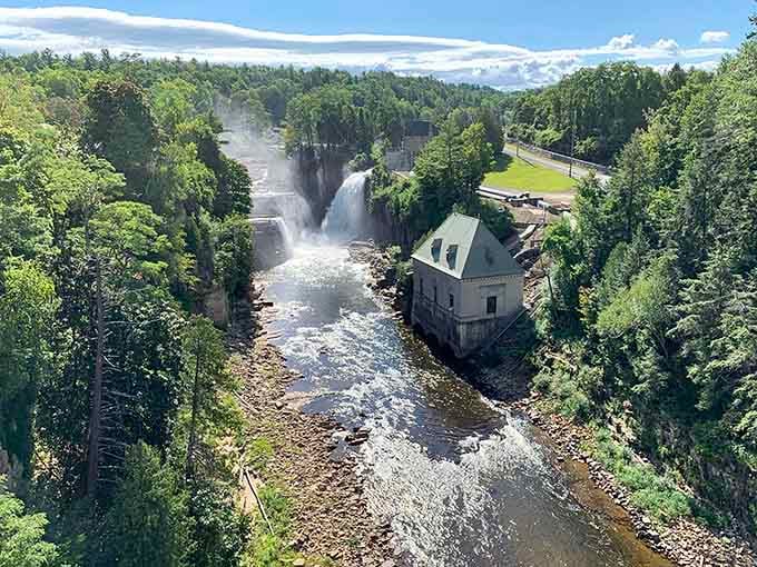 The historic stone building watches over rushing waters like a patient guardian from another century's postcard.