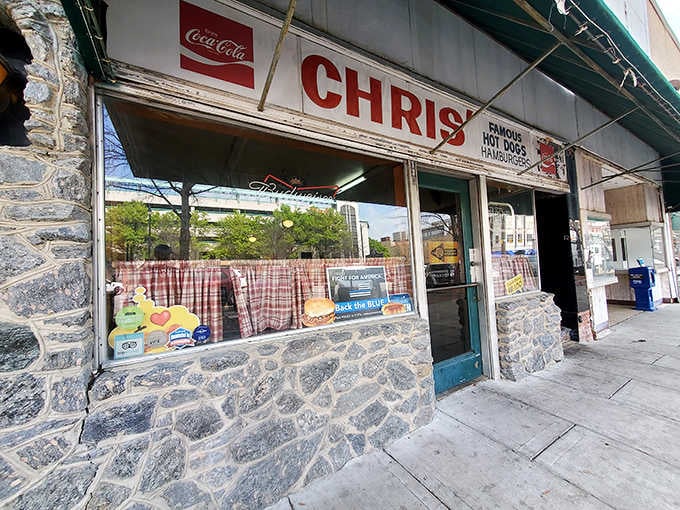 Classic Coca-Cola signage and checkered curtains frame the entrance to this beloved hot dog institution that's fed generations.