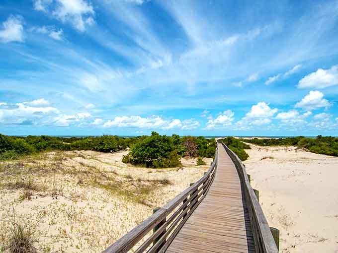 That wooden boardwalk stretches toward pristine dunes and endless sky&mdash;your personal runway to coastal paradise awaits.