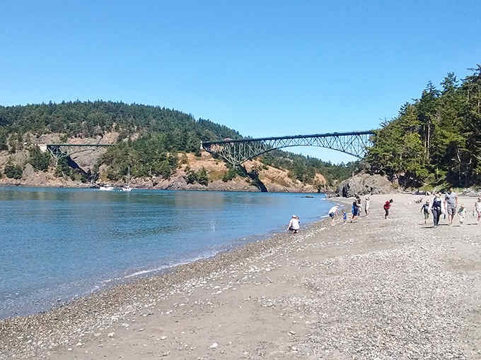 Beach wanderers discover the perfect blend of mountain, sea, and sky beneath this architectural marvel spanning the pass.