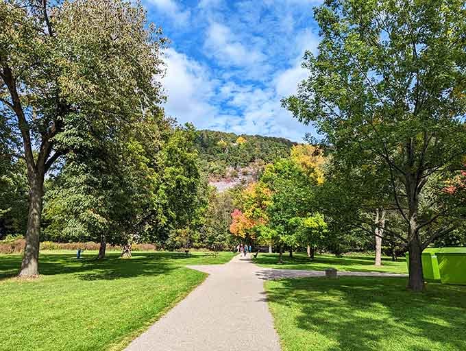 A peaceful walking path winds through autumn colors where the only traffic jam involves squirrels and songbirds.