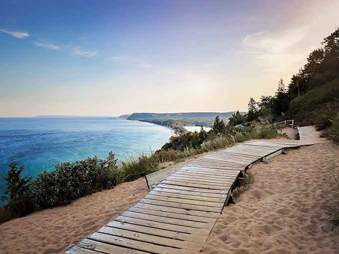 That sandy boardwalk curves along the bluff like a golden ribbon, delivering you straight to Lake Michigan's turquoise embrace.