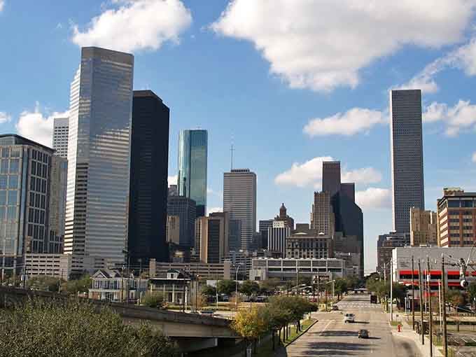 Those towering skyscrapers rise like a modern-day monument to ambition, framed by green spaces that soften the urban edge beautifully.