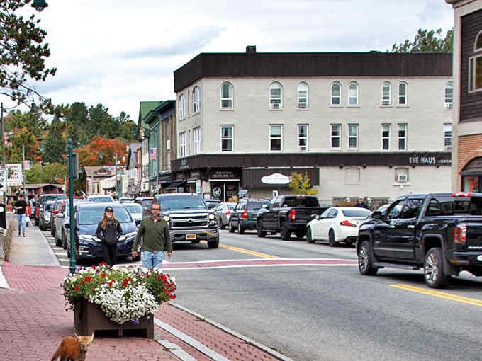 Those flower planters brighten the sidewalks while the Adirondacks stand guard, creating a scene Norman Rockwell would've painted twice.