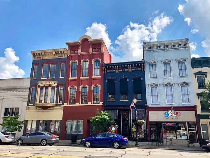 These colorful buildings stand shoulder-to-shoulder like old friends sharing stories under fluffy summer clouds.