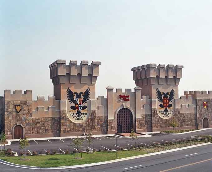 The fortress facade stretches wide with battlements that would make King Arthur jealous—dinner theater at its grandest.