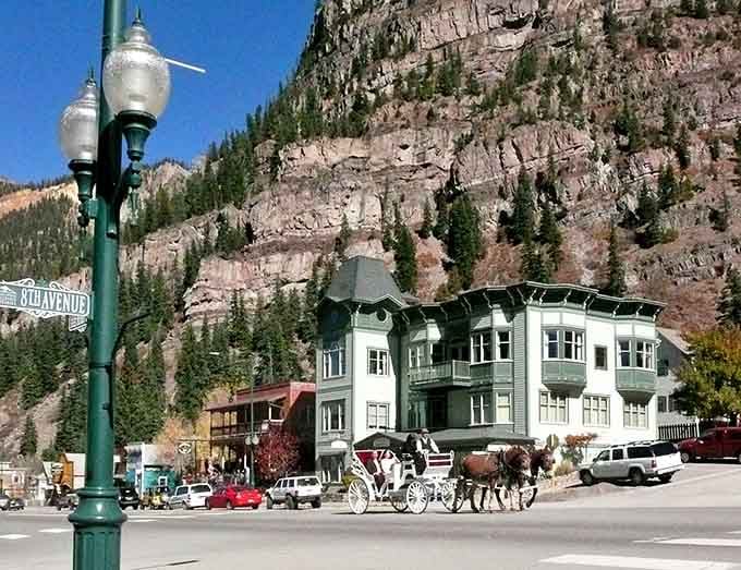That horse-drawn carriage rolling past ornate street lamps proves some places refuse to rush into the modern world.