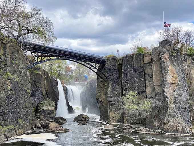 Industrial ruins meet raw power beneath that graceful bridge—history and nature in perfect, dramatic harmony.