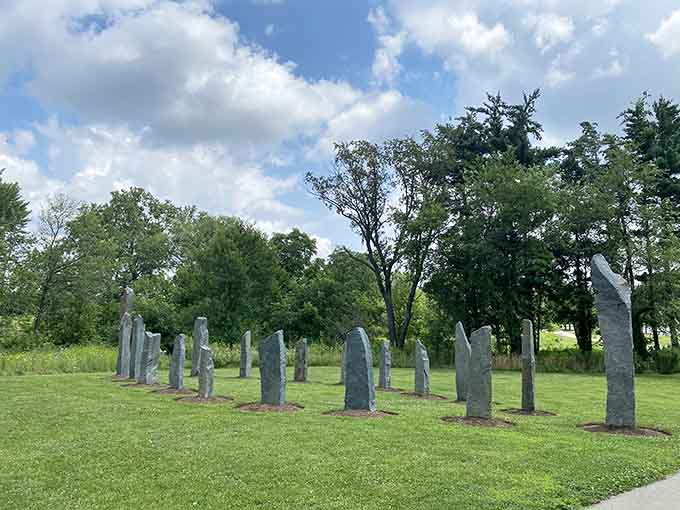 These mysterious stone sentinels stand like ancient guardians watching over the perfectly manicured lawn beneath blue skies.
