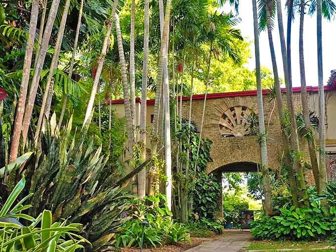 Towering palms frame a hidden archway where tropical greenery creates nature's own cathedral of calm and wonder.