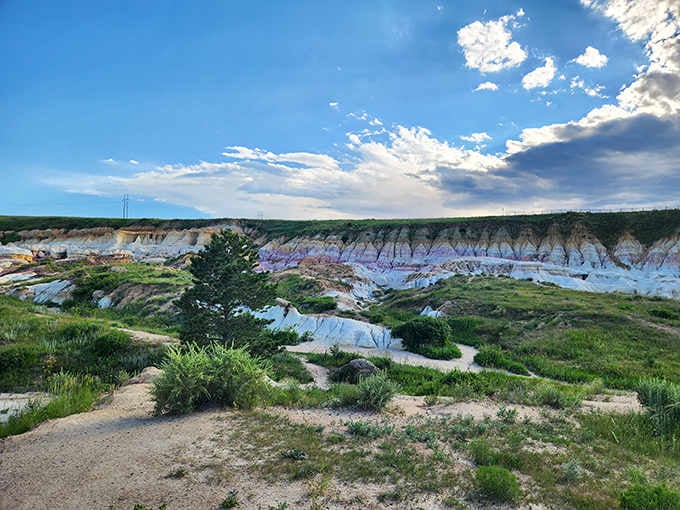 These colorful formations stretch across the landscape like a geological layer cake under endless Colorado skies.