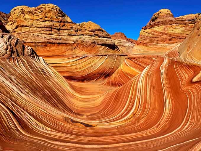 These sandstone waves froze mid-crash millions of years ago, creating nature's most spectacular optical illusion in the desert.
