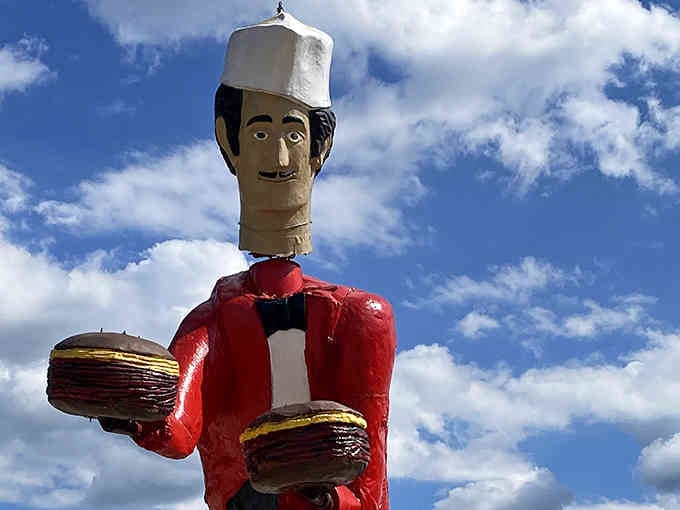 Under brilliant blue skies, this giant bobblehead serves up double burgers and unforgettable photo opportunities for passing travelers.